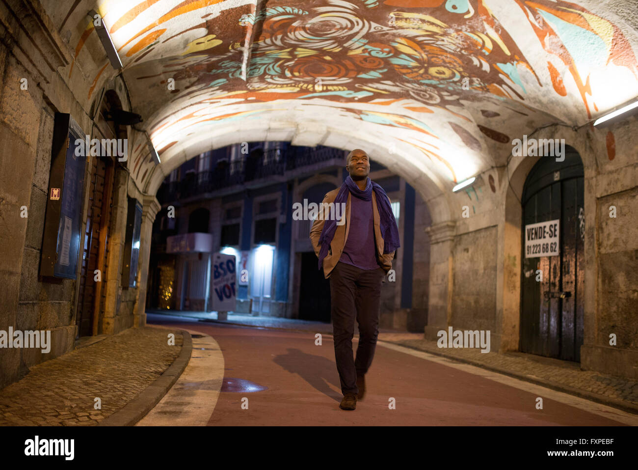 Traveler strolling through graffitied walkway Stock Photo - Alamy