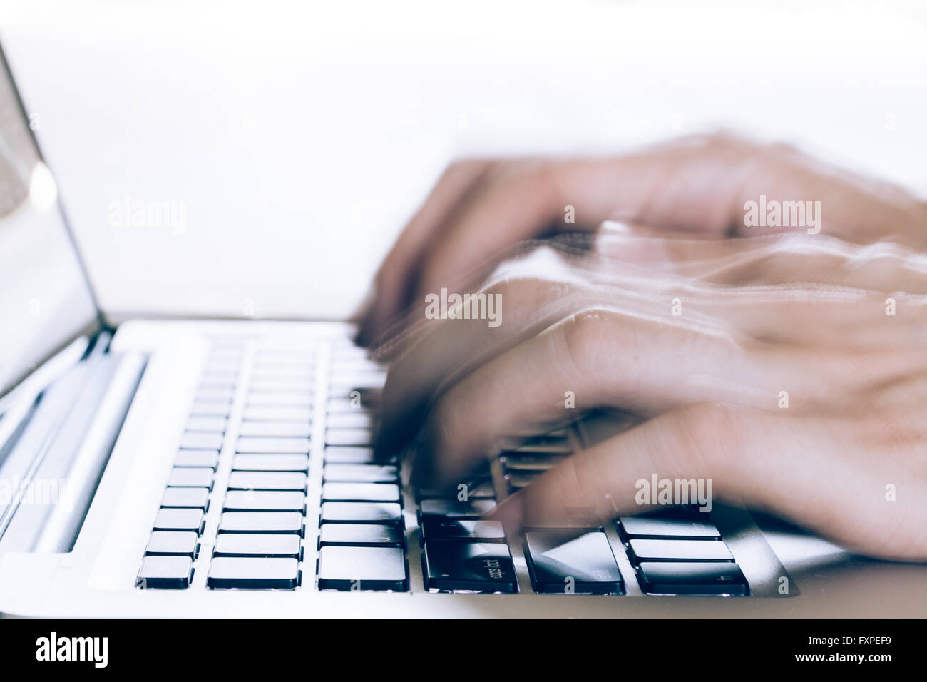 Human Hands typing on laptop in blurred motion with copy space above ...