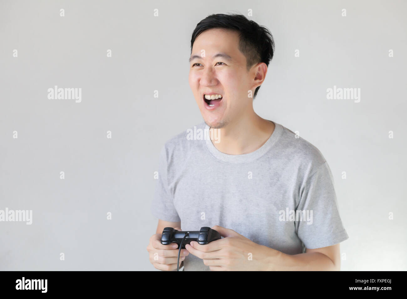 Young Asian man playing video games - in white isolated background ...