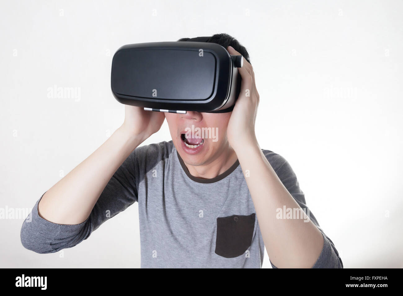 Asian man wearing VR goggle and immersing himself in VR multimedia in ...