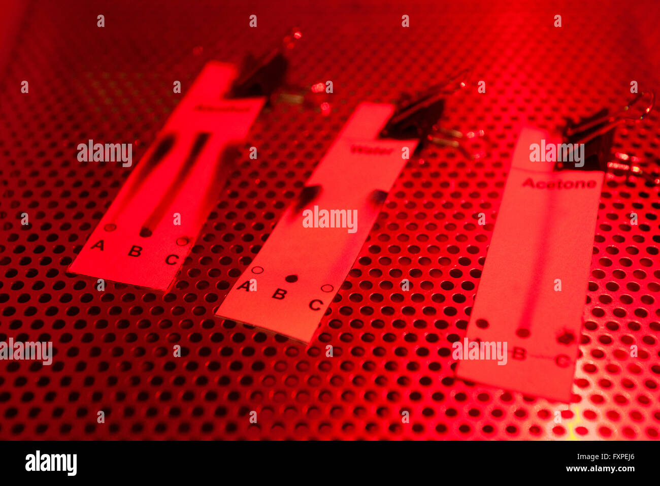 Chemical test strips illuminated by red light Stock Photo - Alamy