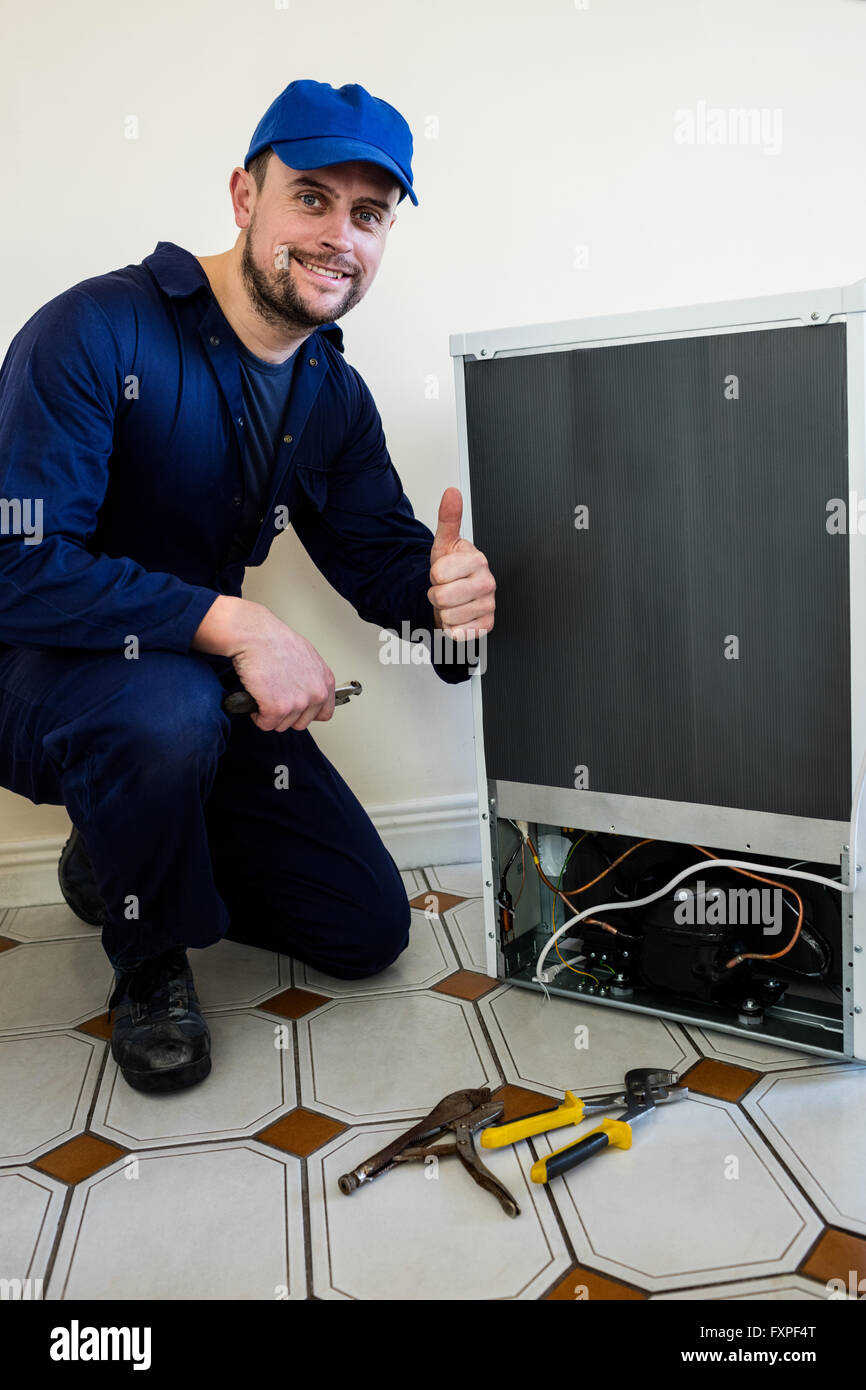 Portrait of handyman repairing a machine at home Stock Photo - Alamy
