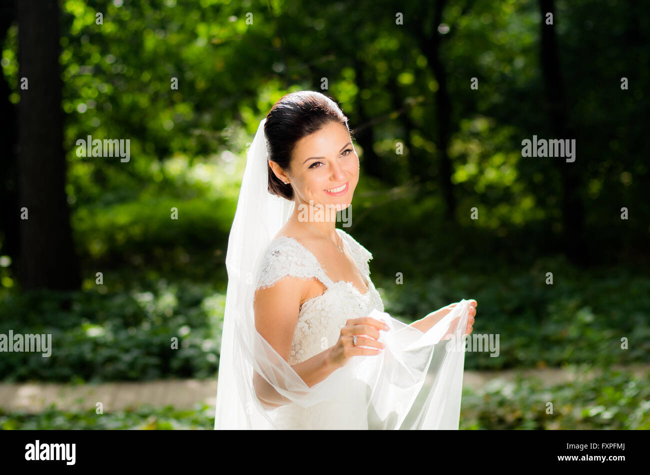 Portrait of the smiling bride in the garden in the backlight Stock ...
