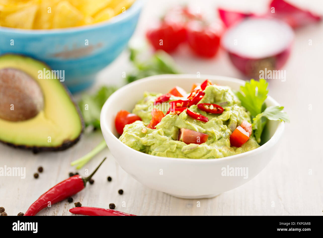 Guacamole with avocado and tomatoes mexican food. white wooden ...