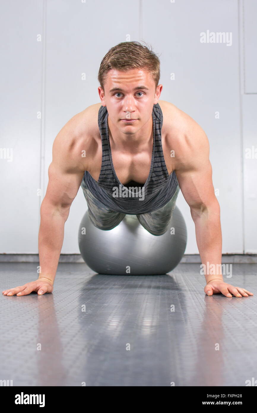 Young man performing push ups with pilates ball Stock Photo - Alamy