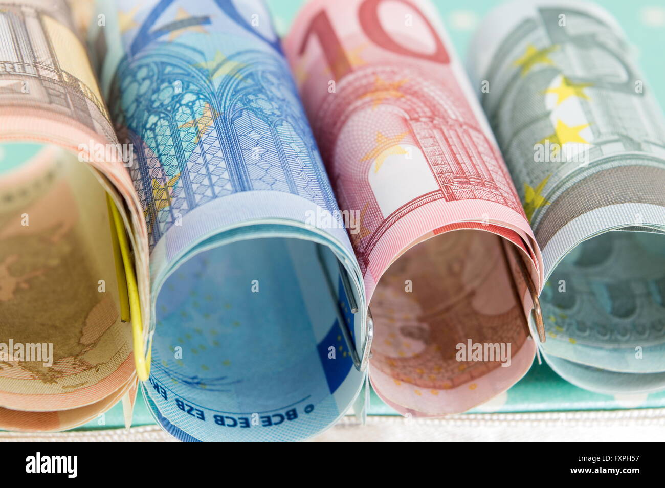 Rolled up euro bills forming a row Stock Photo - Alamy