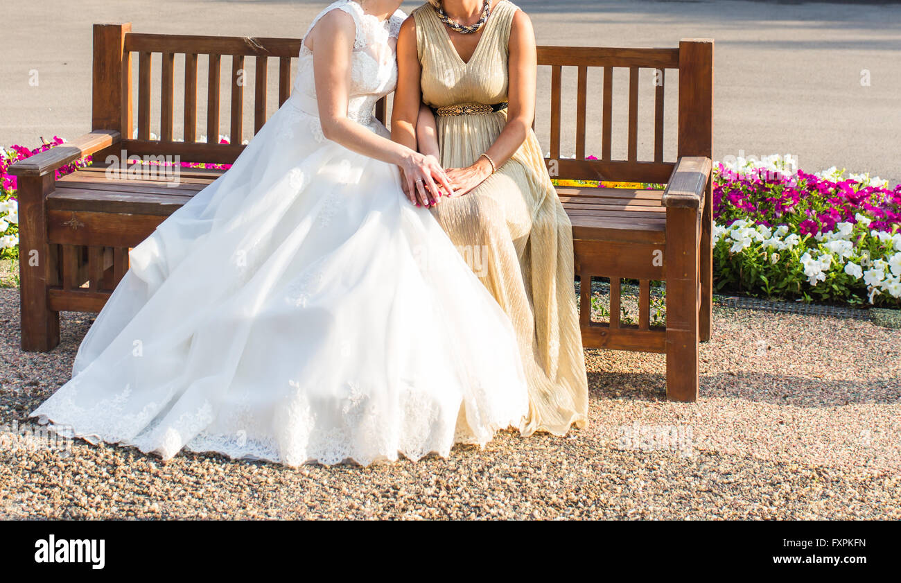 Bride With Mother sitting on a bench outdoors Stock Photo - Alamy