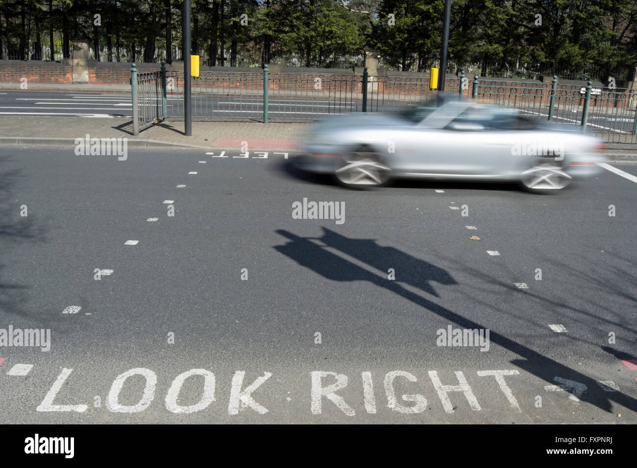 look right road marking at a pelican crossing with passing car seen in ...