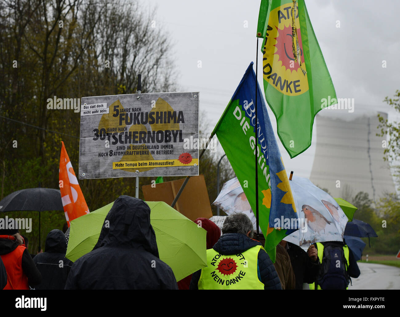 Anti-nuclear activists carry banners and signs, with the cooling tower ...