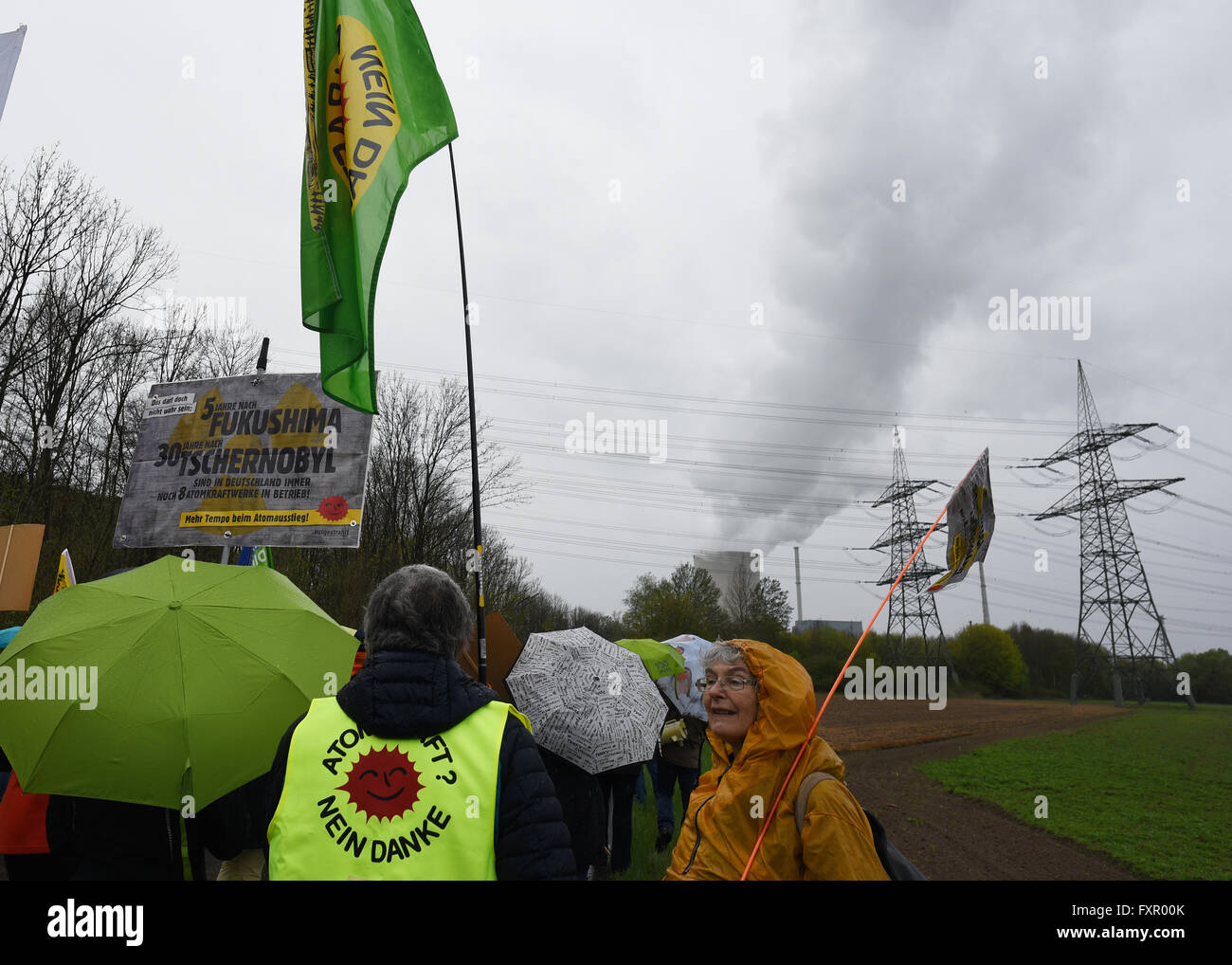 Anti-nuclear activists carry banners and signs, with the cooling tower ...