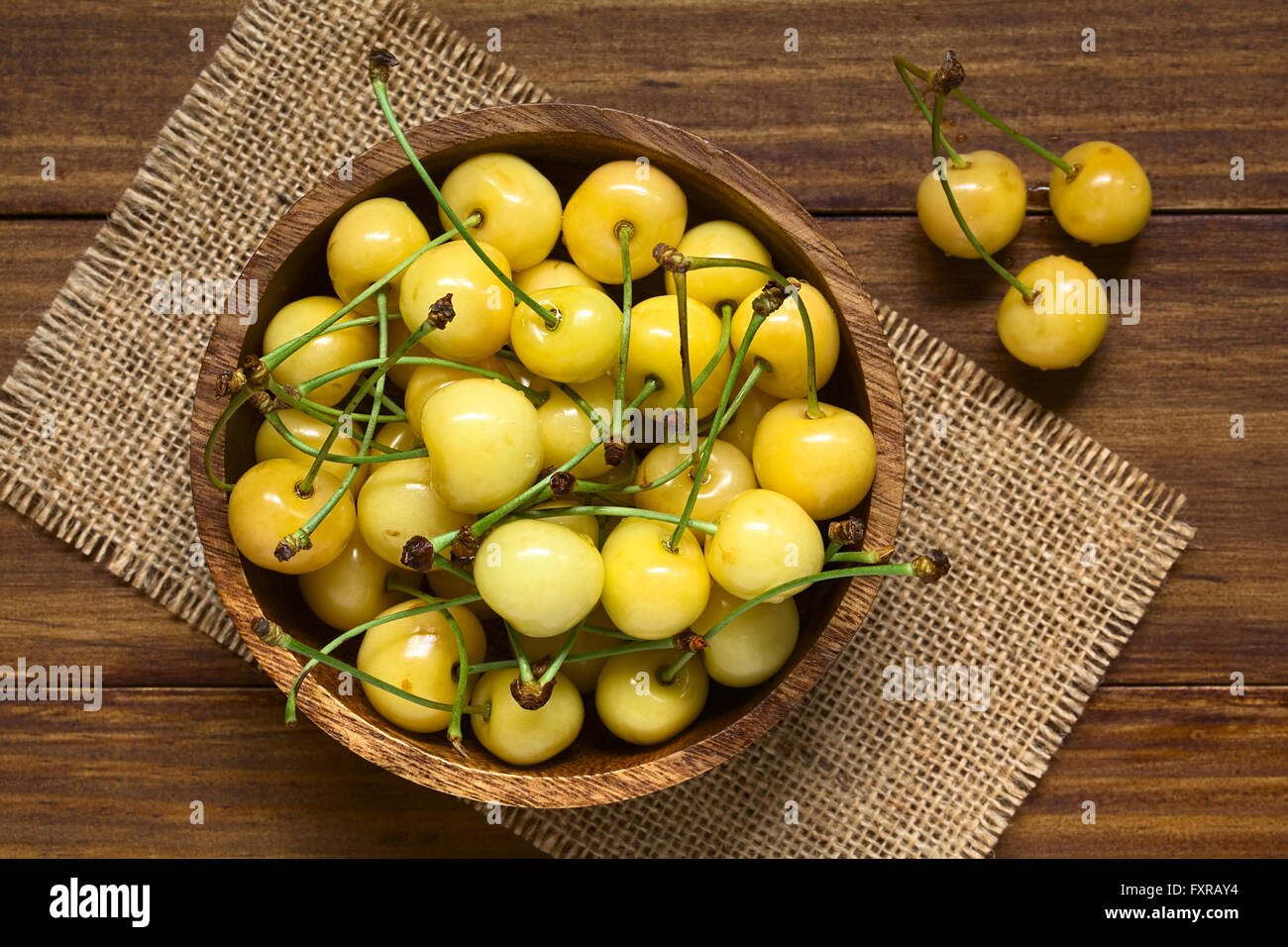 Ripe yellow or Rainier cherry in wooden bowl, photographed overhead on ...