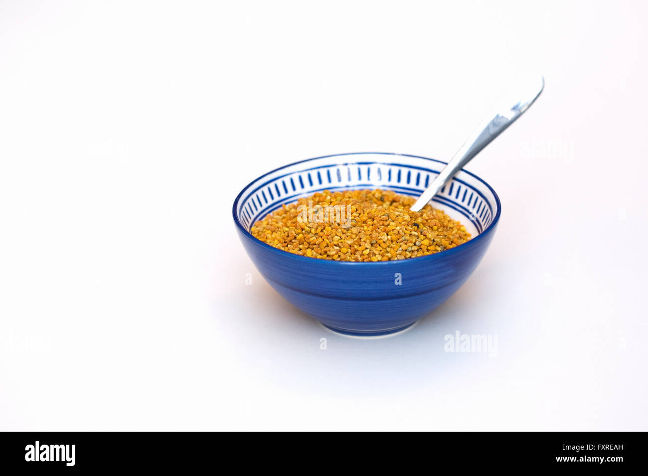 A blue bowl of bee pollen on a white background Stock Photo - Alamy