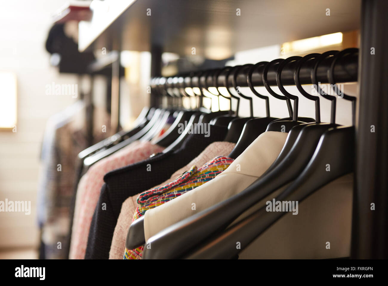 Clothes on hangers in shop. Close up. Shallow dof Stock Photo - Alamy
