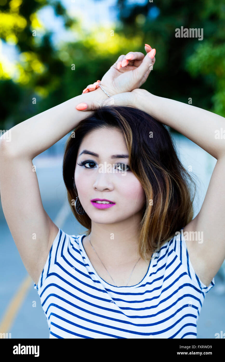 Asian Woman Outdoor Portrait Arms On Head Stock Photo - Alamy