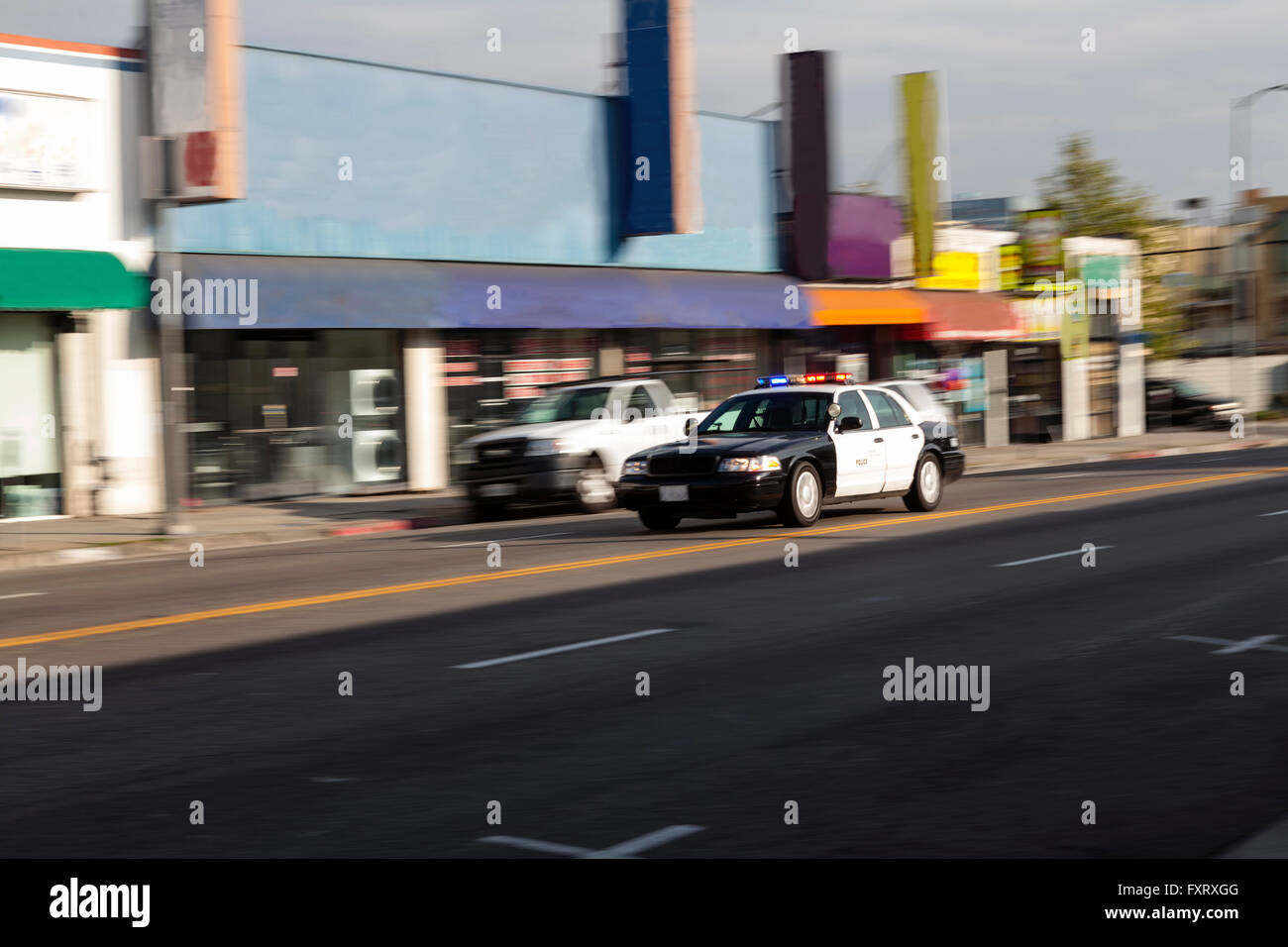Police Car Going Down Street With Lights Stock Photo - Alamy