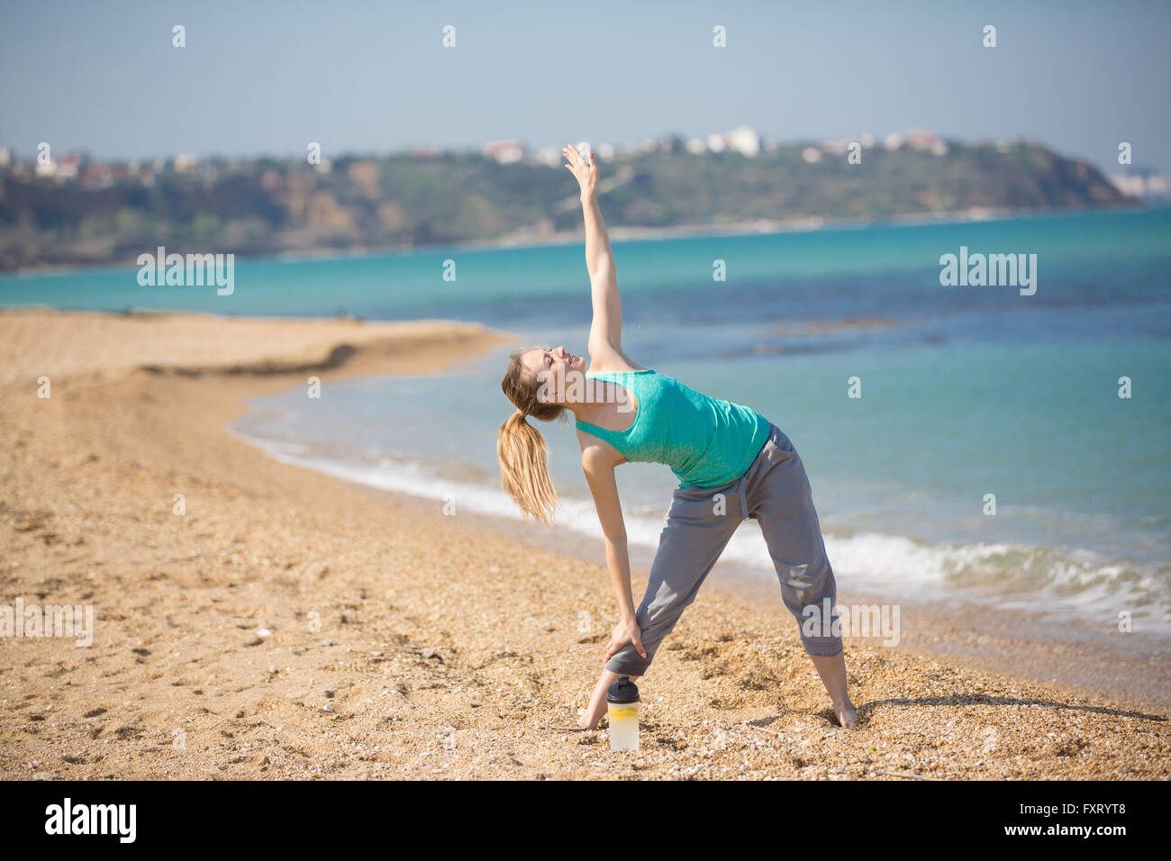 Young woman exercising on the beach Stock Photo - Alamy