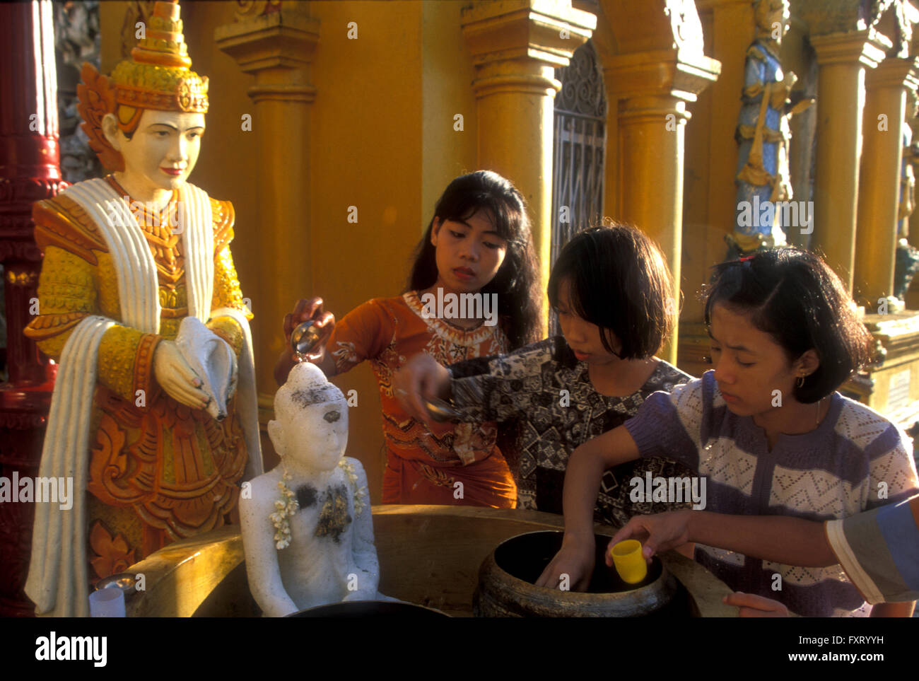 Women bathing a small statue of the Buddha on the occasion of Wesak ...