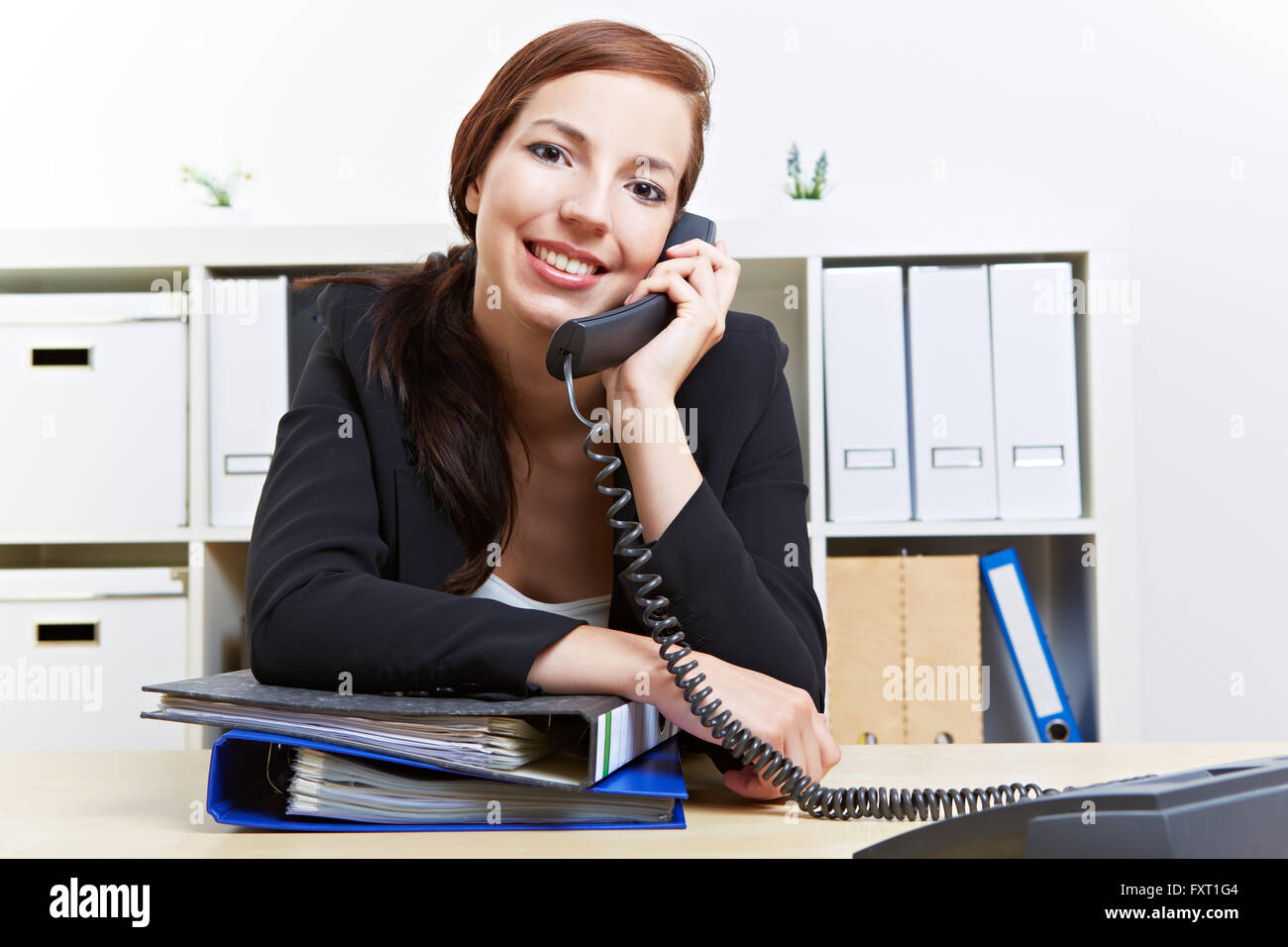 Attractive happy business woman making a phone call in her office Stock ...