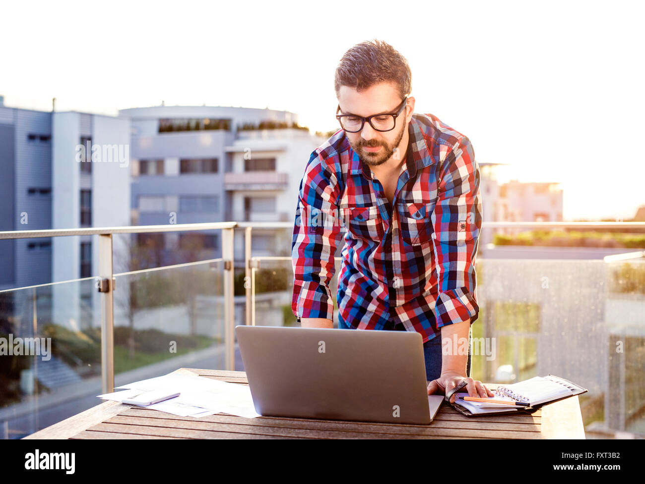 Businessman working from home on laptop, standing on balcony Stock ...