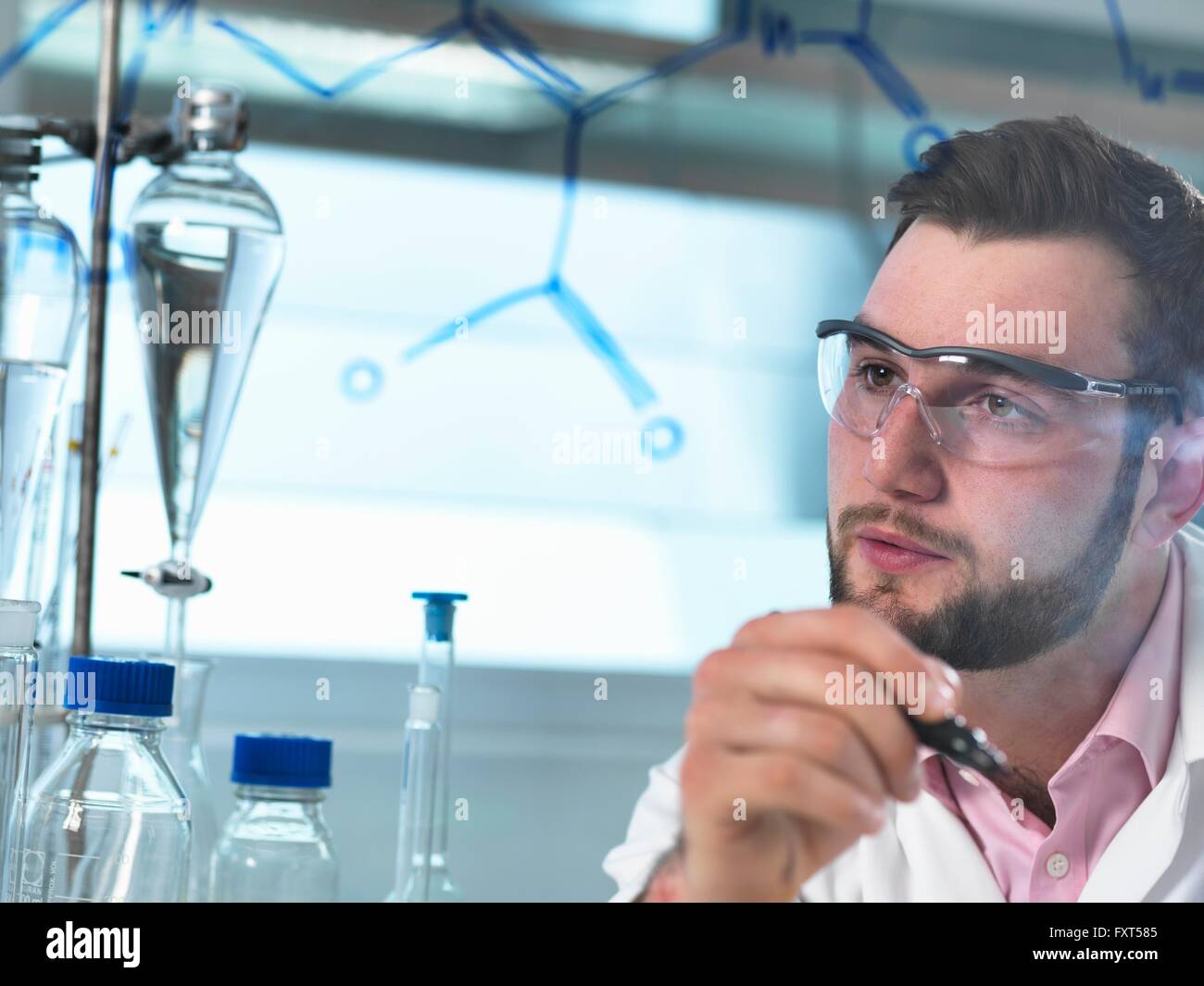 Young male scientist looking at antibiotic chemical formula in ...