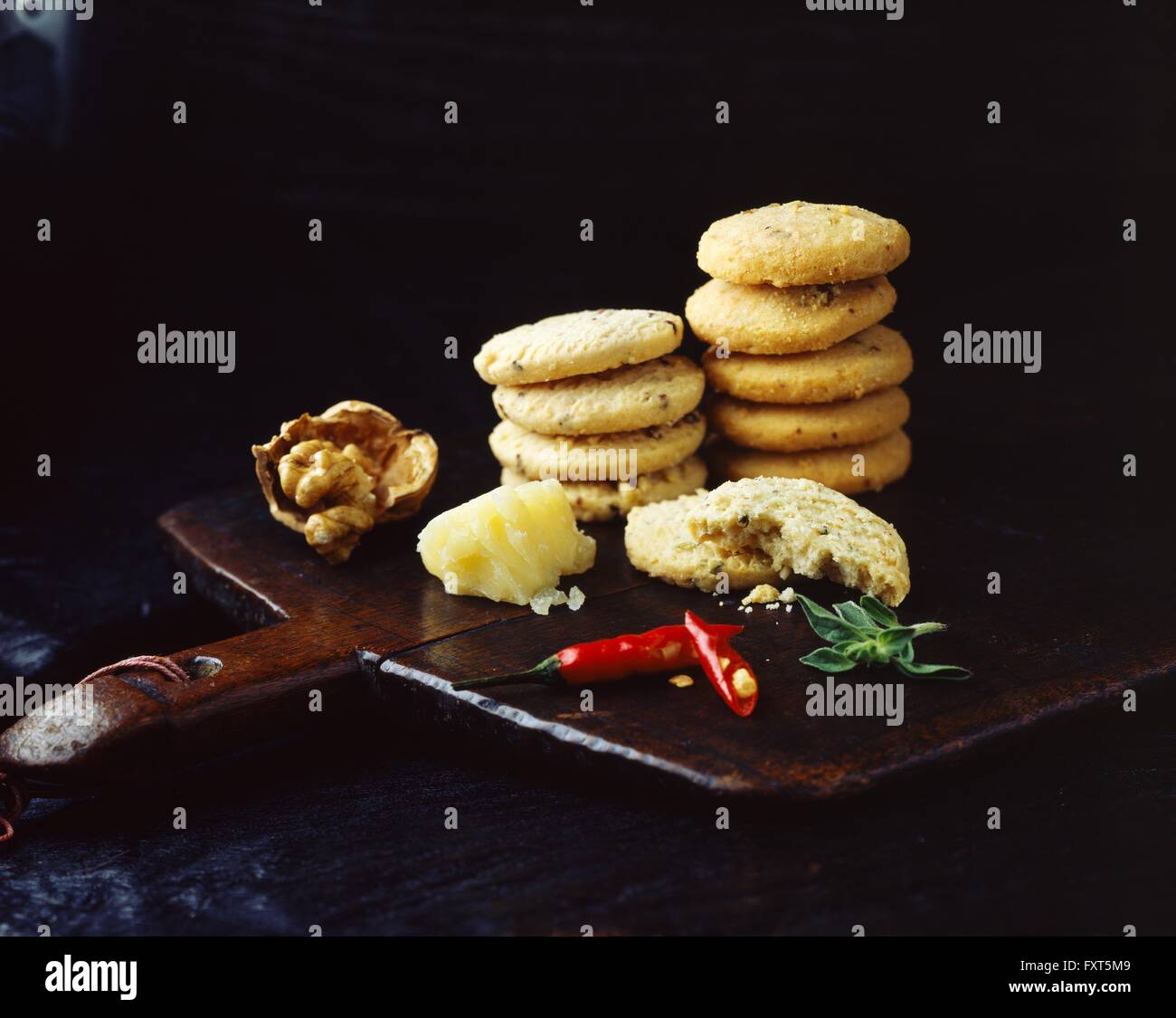 Stacks of homemade walnut chilli cheese oatcakes on vintage wooden tray ...