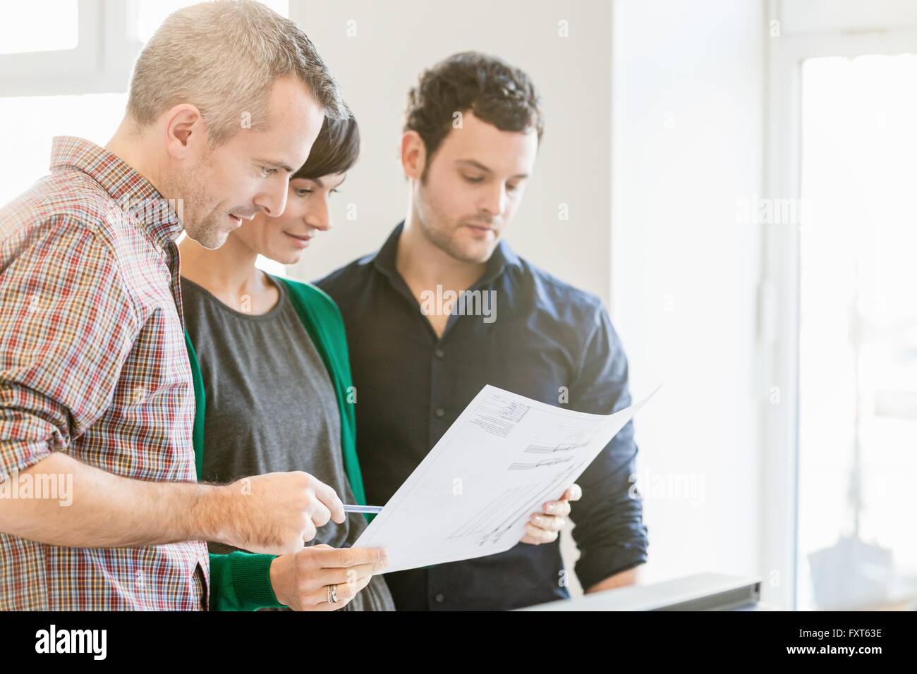 Colleagues looking at paperwork Stock Photo - Alamy