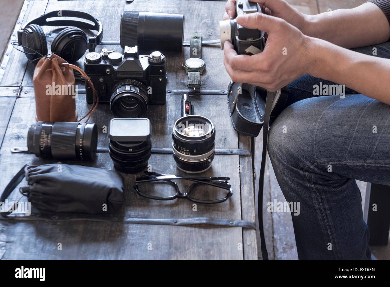 Photographer preparing camera and accessories at desk Stock Photo - Alamy