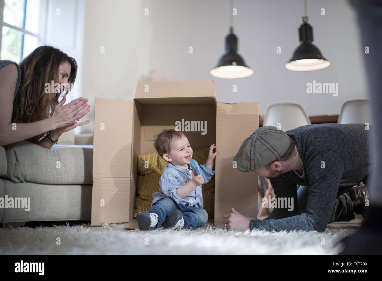 Parents playing with baby boy and cardboard box Stock Photo - Alamy