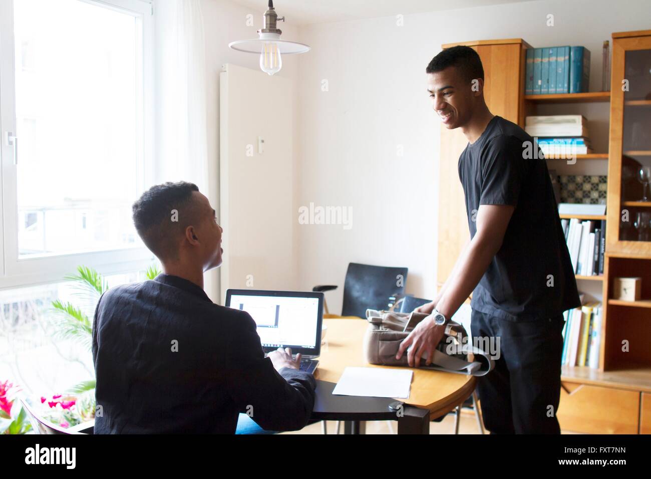 Twin brothers at home, using laptop Stock Photo - Alamy