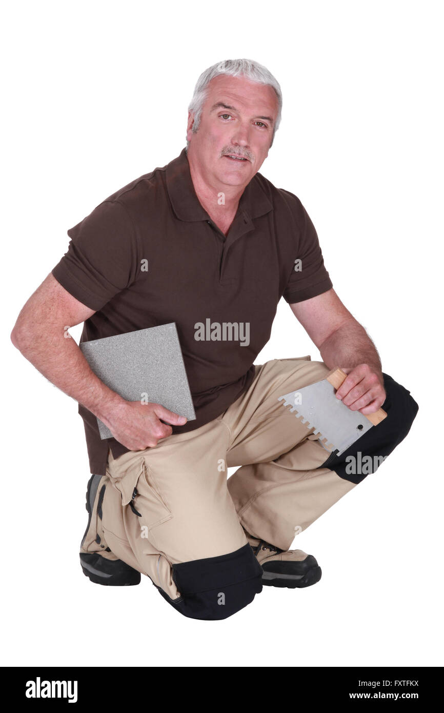 Middle-aged man fitting tiles Stock Photo - Alamy