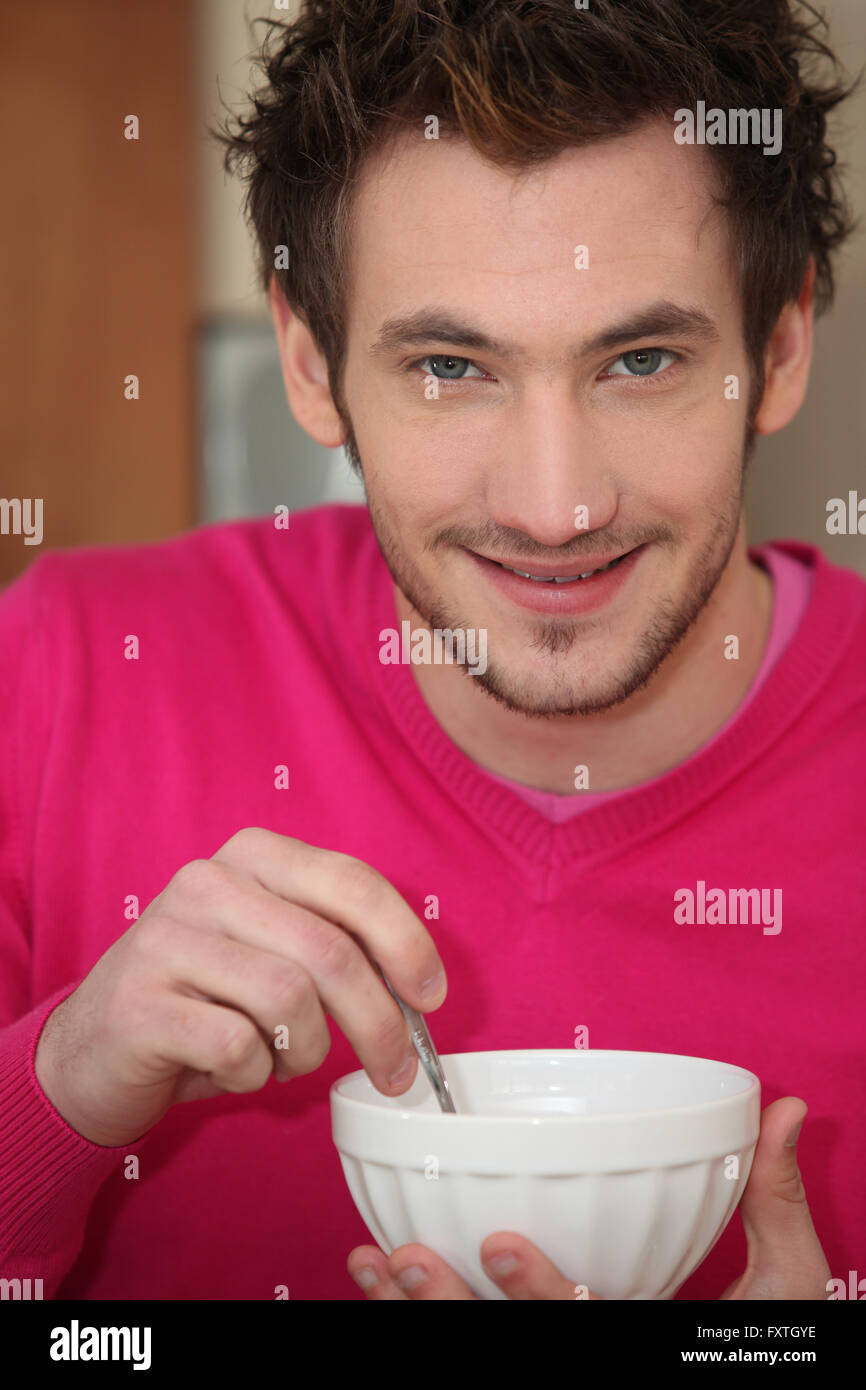 Young man eating cereal Stock Photo - Alamy