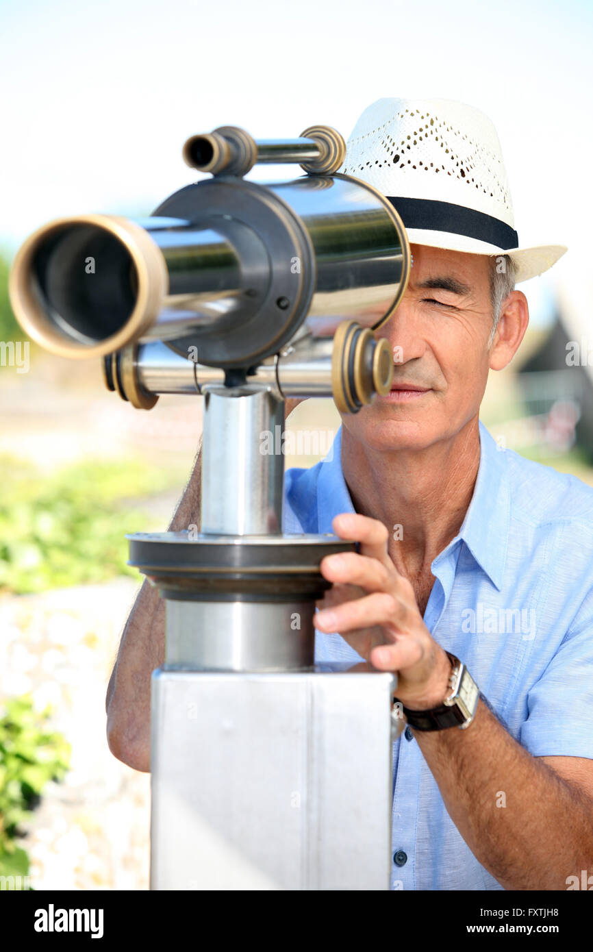 Man looking through telescope Stock Photo - Alamy