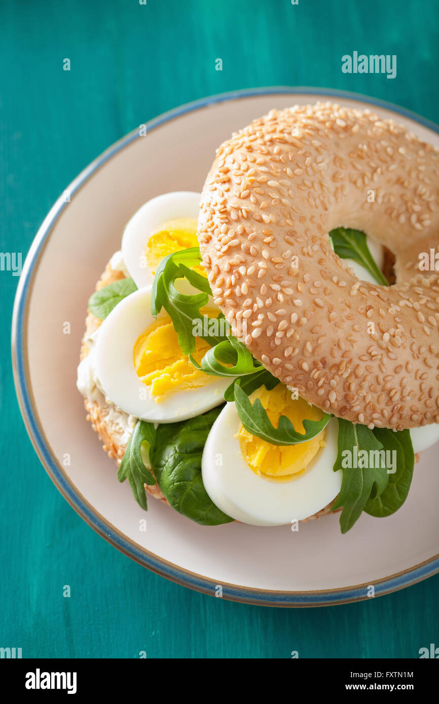 breakfast sandwich on bagel with egg cream cheese arugula Stock Photo ...
