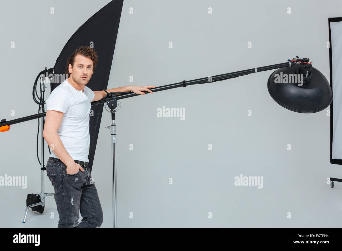 Handsome male photographer preparing lighting equipment in studio Stock ...