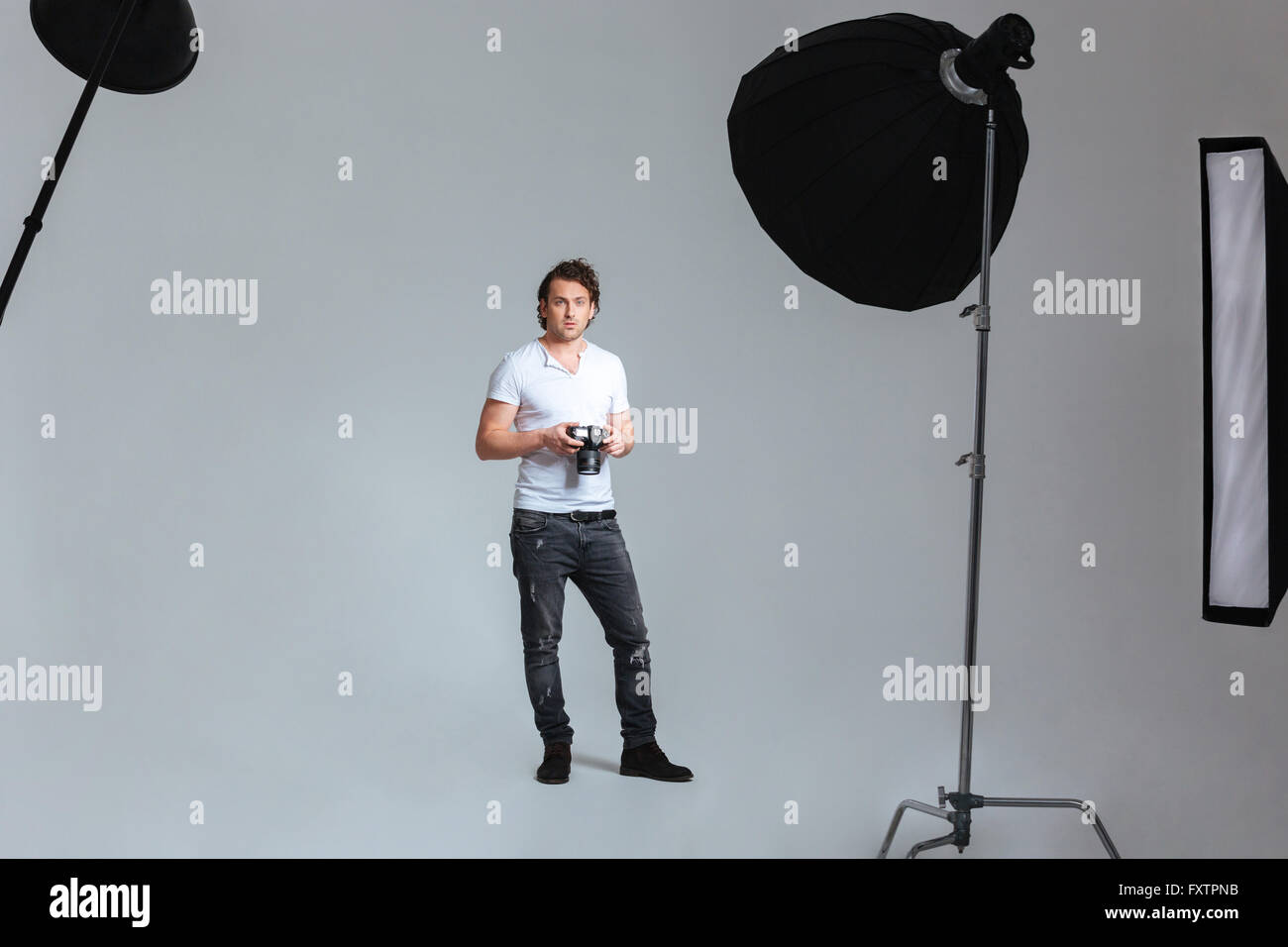 Male photographer standing in professional studio with equipment Stock ...