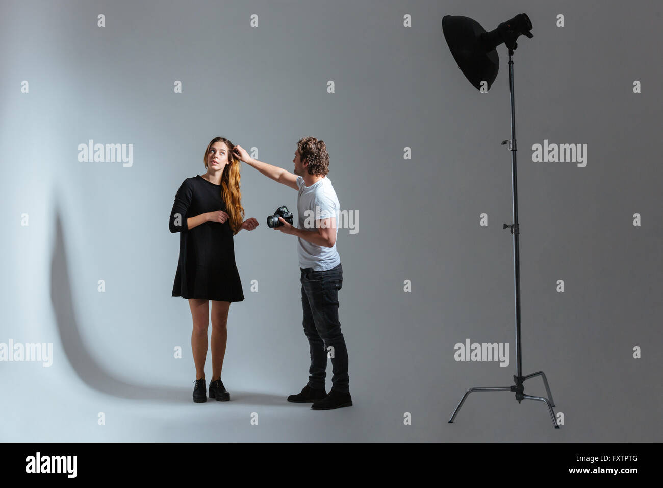 Male photographer working with female model in studio with equipments ...