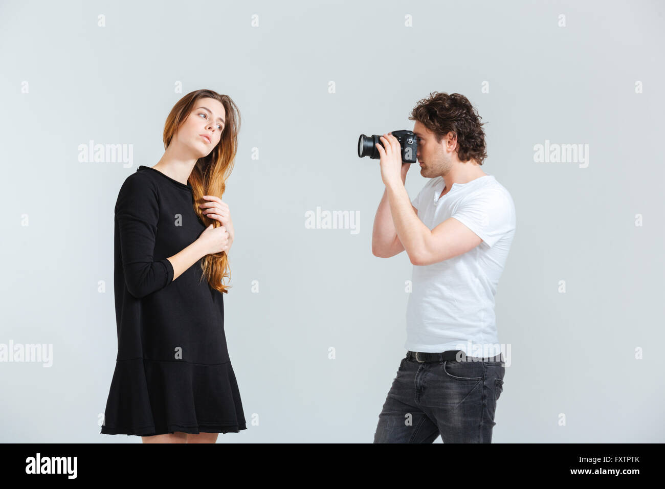 Man photographing female model isolated on a white background Stock ...