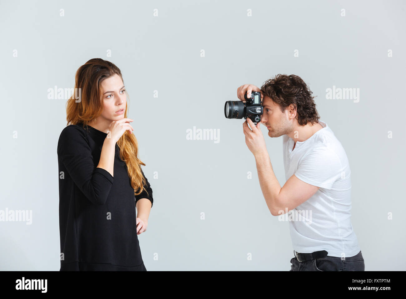 Man photographing female model isolated on a white background Stock ...