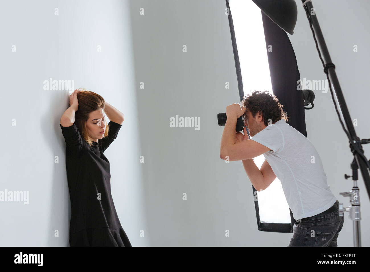 Man photographing female model in professional studio with equipment ...