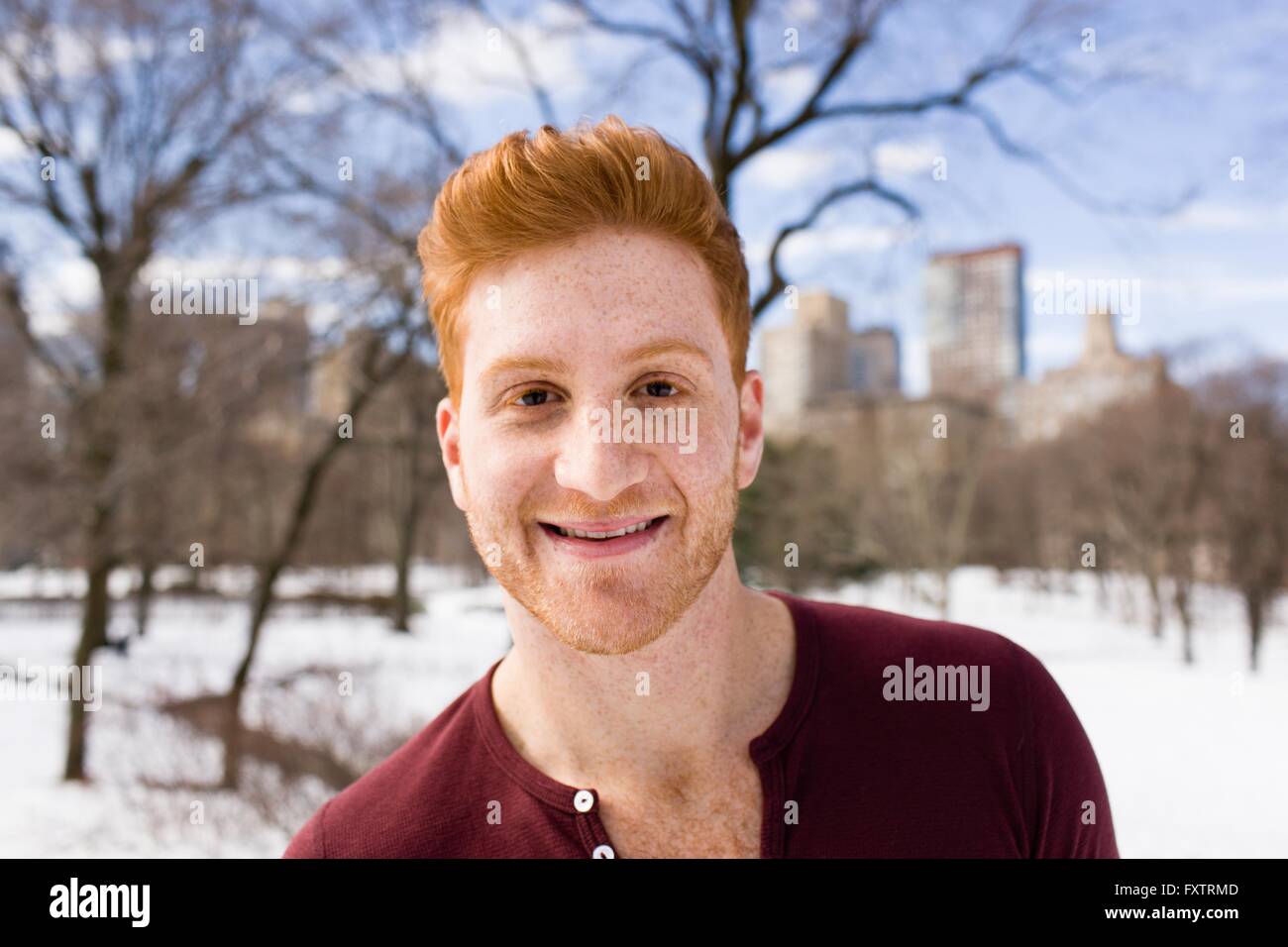 Portrait of red haired young man in snowy Central Park, New York, USA ...
