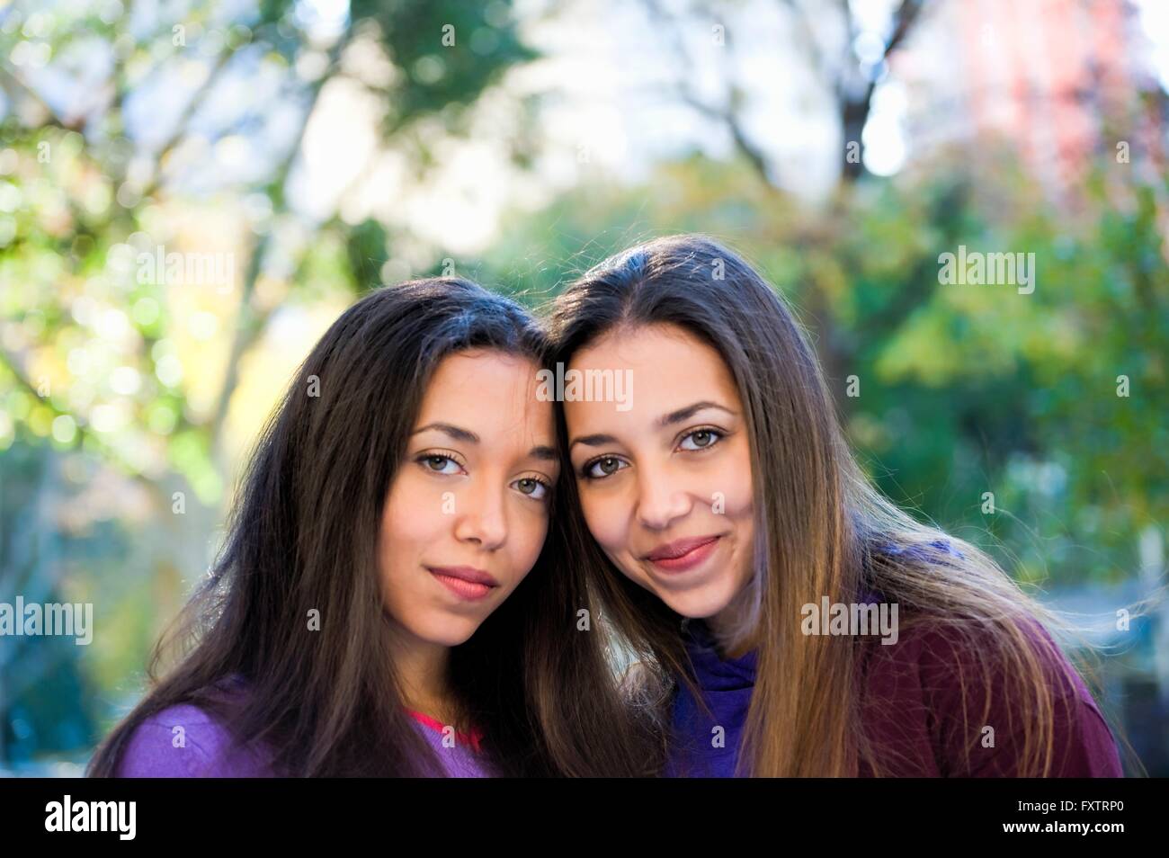 Twin sisters smiling in park Stock Photo - Alamy