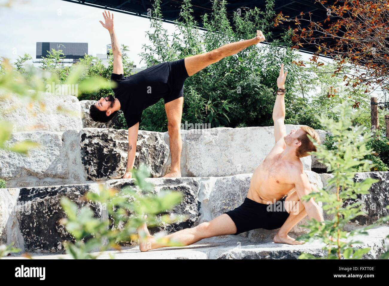 Two men practicing yoga positions together on park step Stock Photo - Alamy