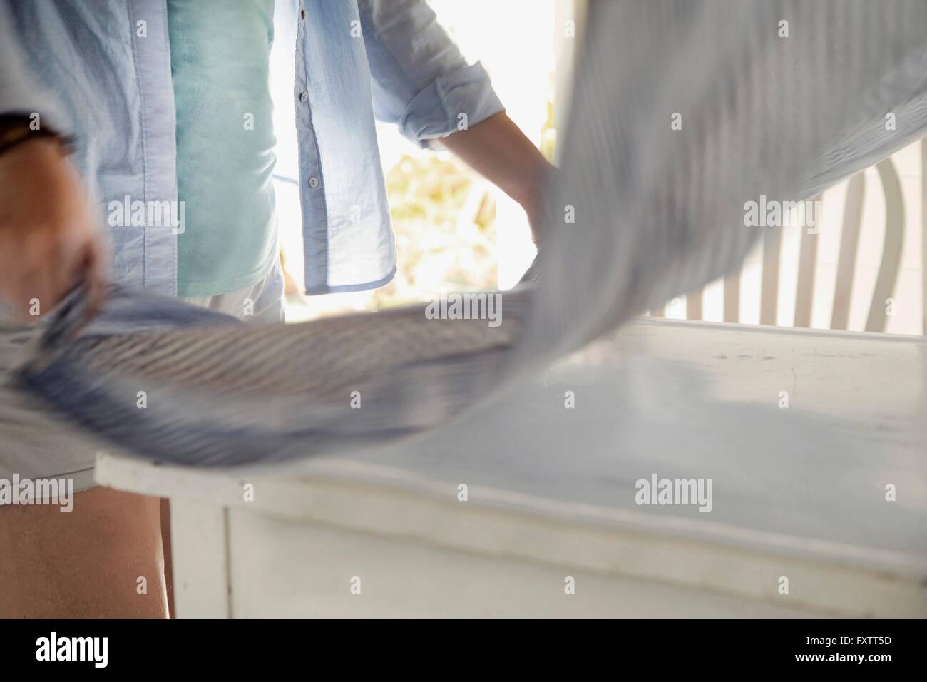 Woman laying cloth over table Stock Photo - Alamy