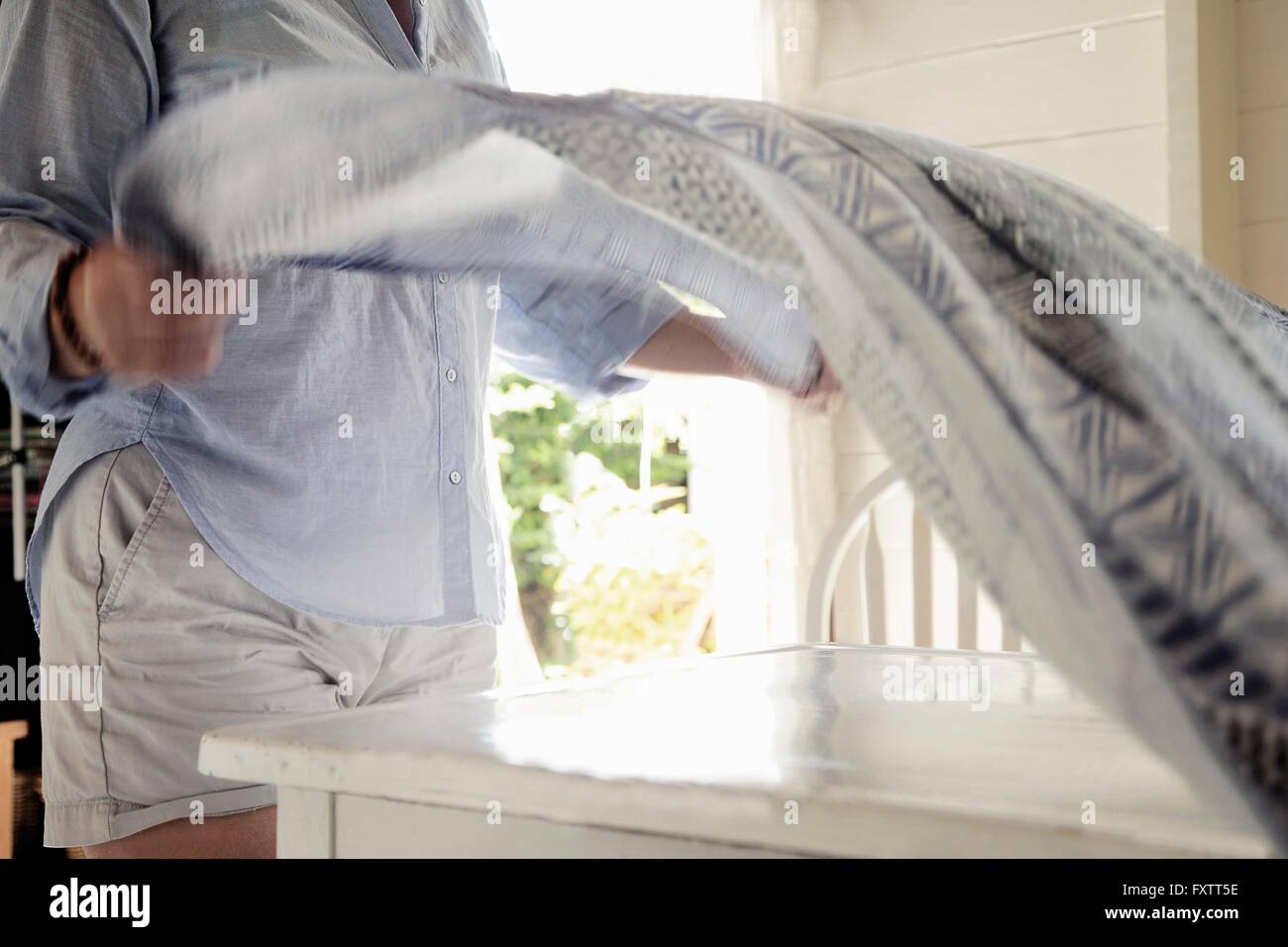Woman laying cloth over table Stock Photo - Alamy