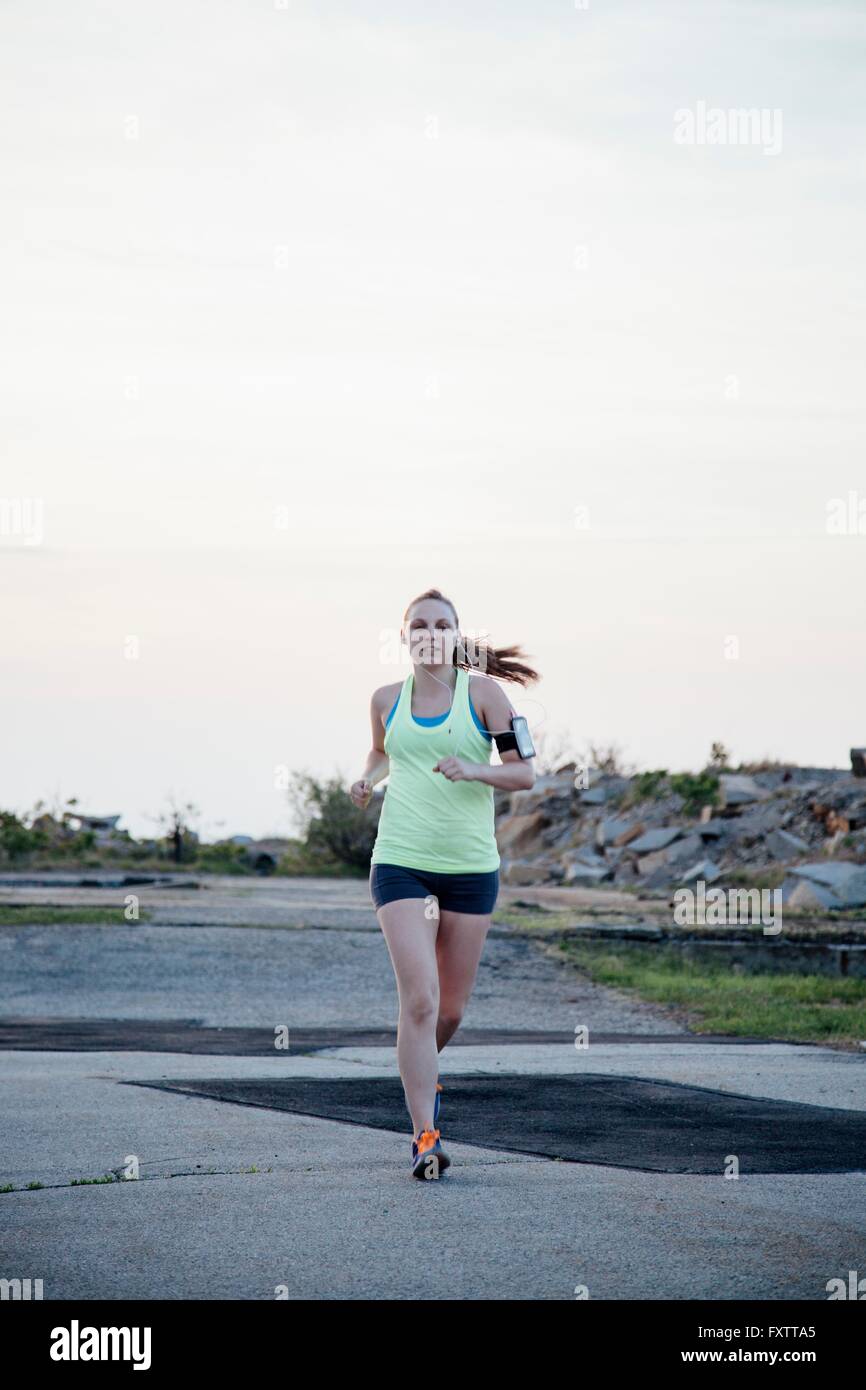 Full length front view of woman wearing activity tracker jogging Stock ...