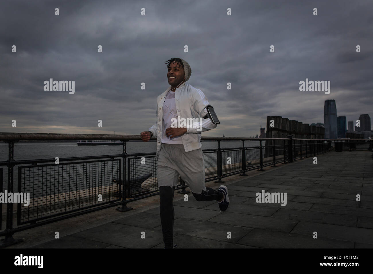 Happy young male runner running on riverside at dawn Stock Photo - Alamy