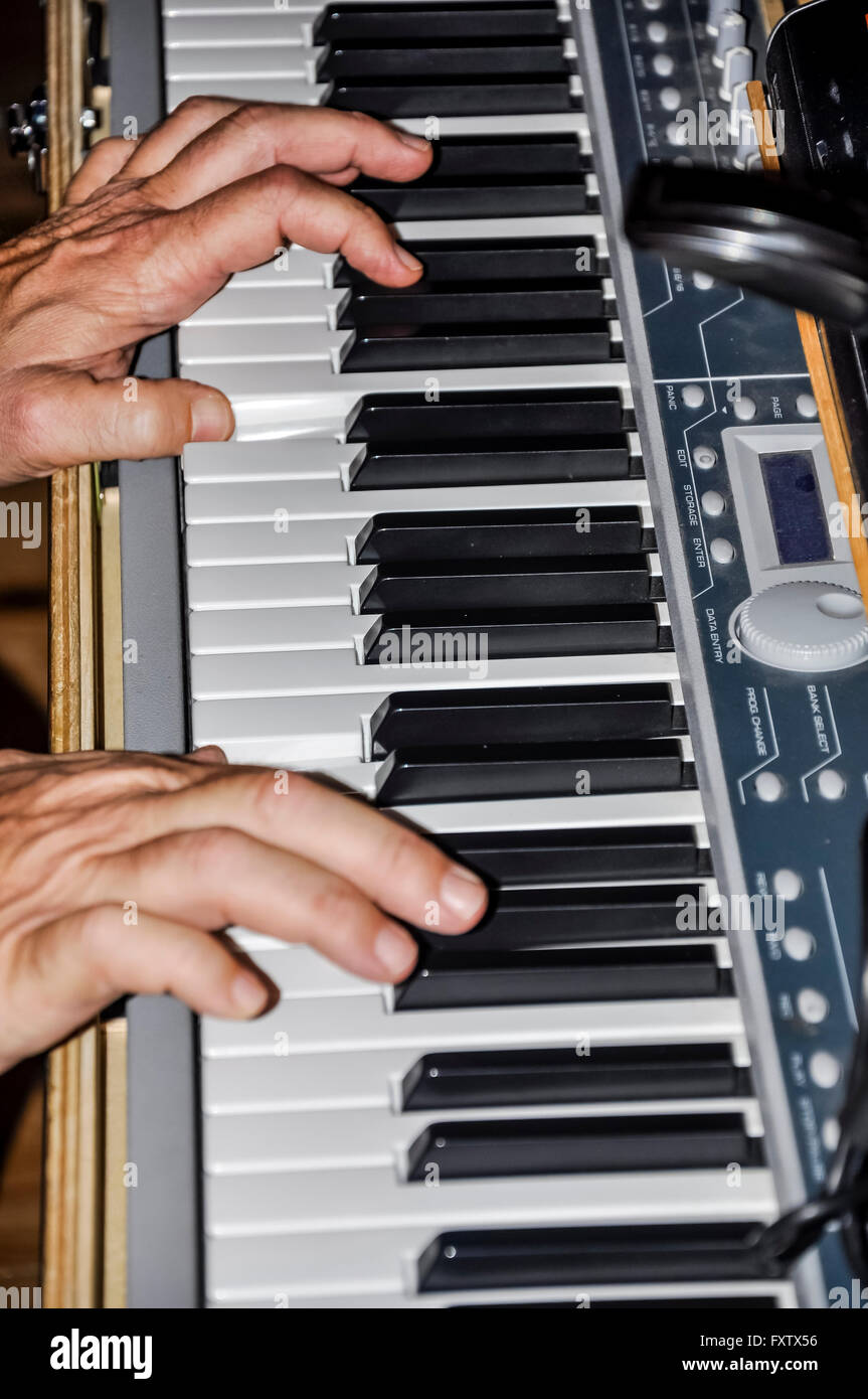 Musician playing on keyboards in a music studio Stock Photo - Alamy