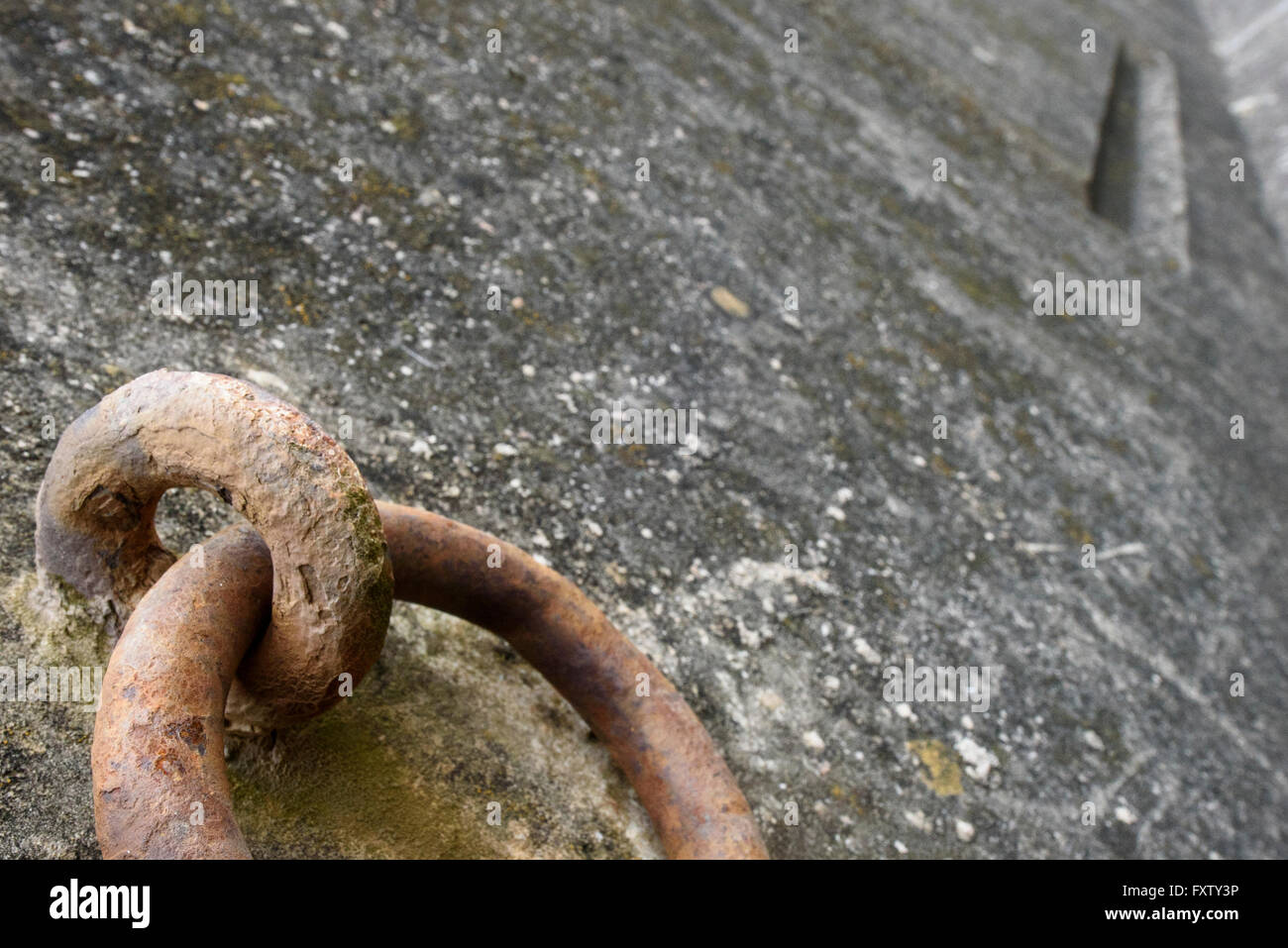 Old rusty ring embedded in the concrete sea wall in North Shore ...