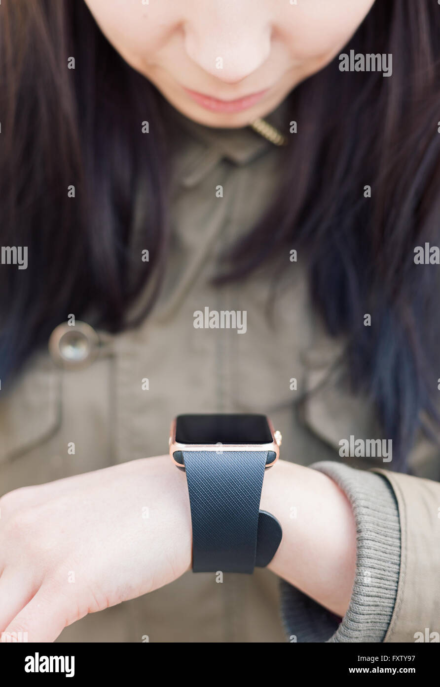 Young girl looking at her smart watch on wrist. This new gadget lets ...