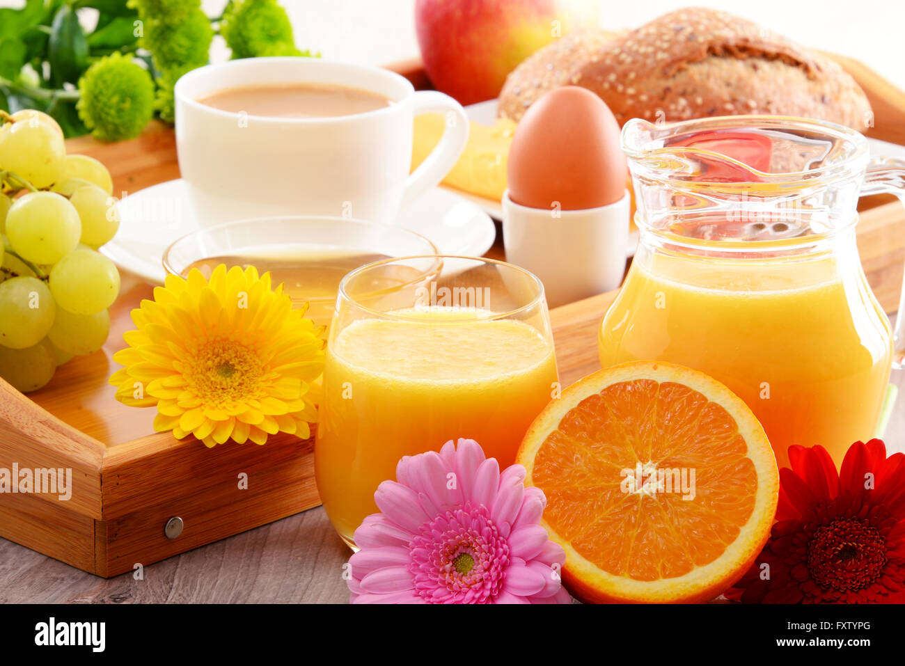 Breakfast on tray served with coffee, orange juice, egg, rolls and ...